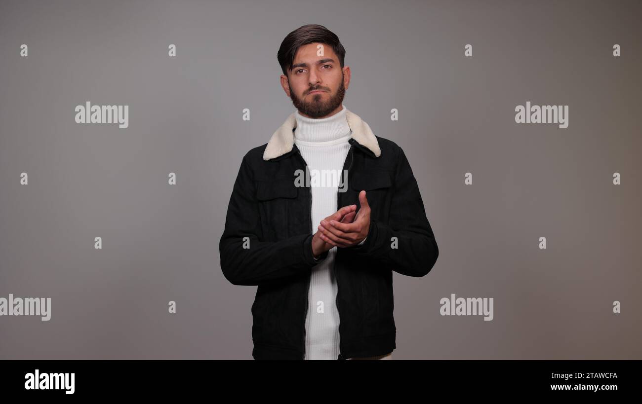 A young man clapping his hands against a gray background Stock Photo ...