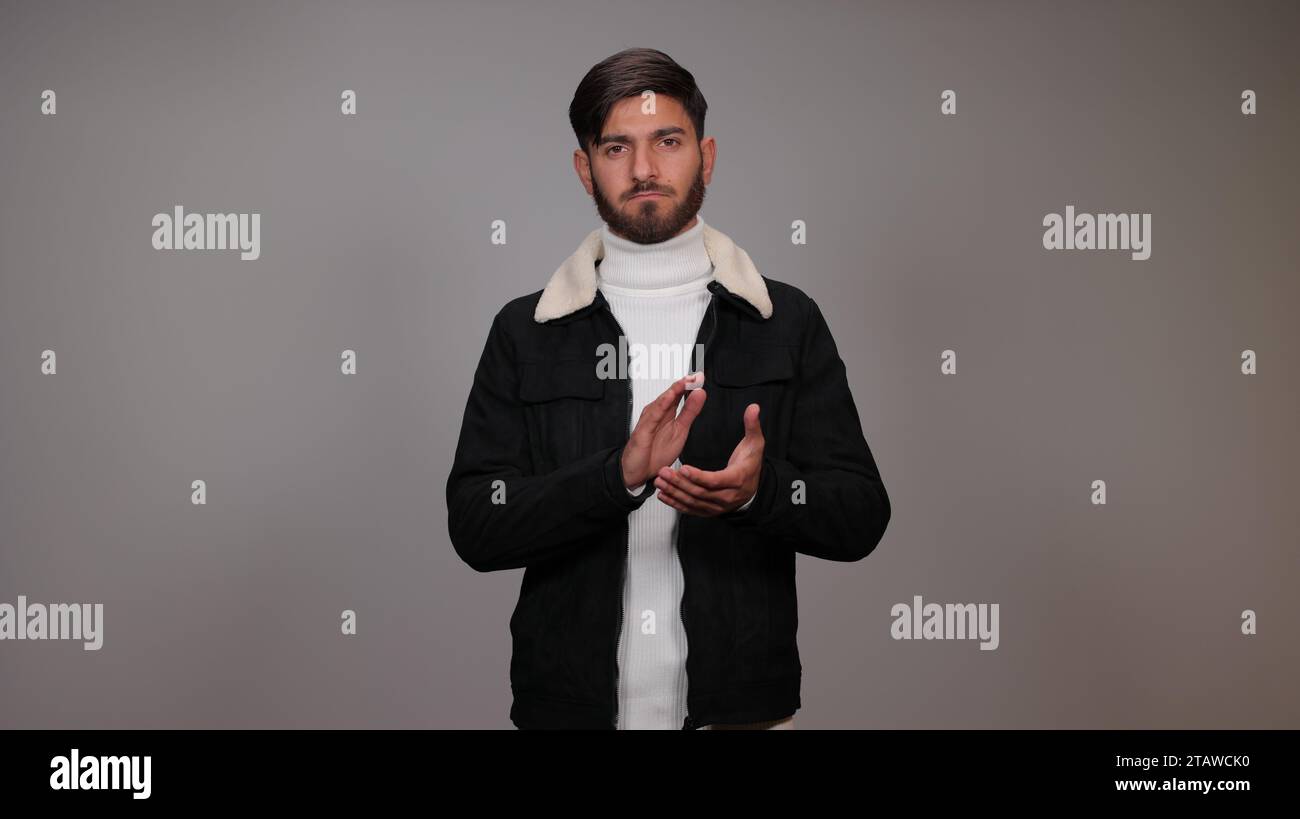 A young man clapping his hands against a gray background Stock Photo ...