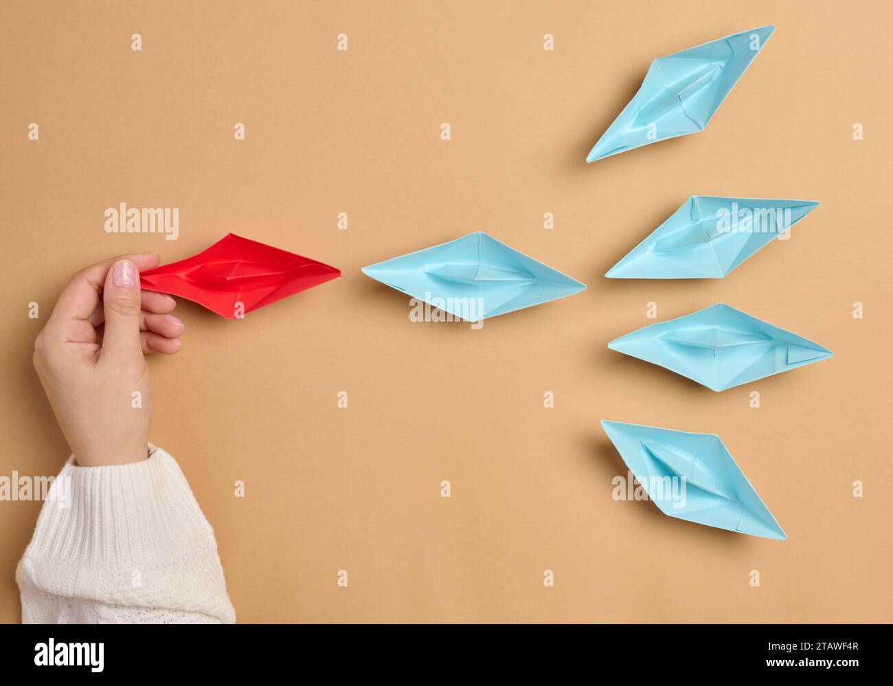 Group of paper boats on a brown background.Concept of a strong leader ...