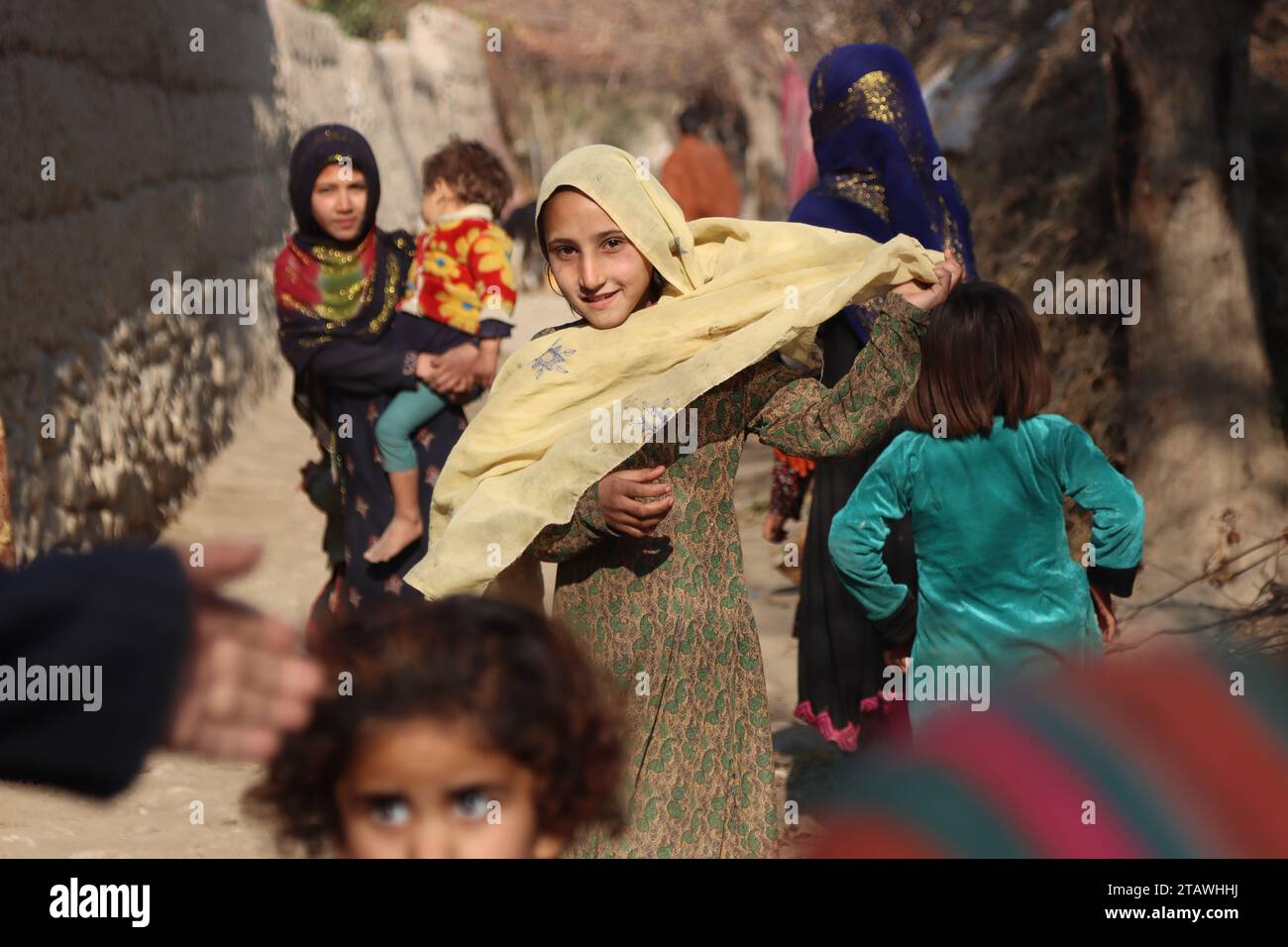 Happy Afghan young girl with a traditional outfit, smiling, looking at ...