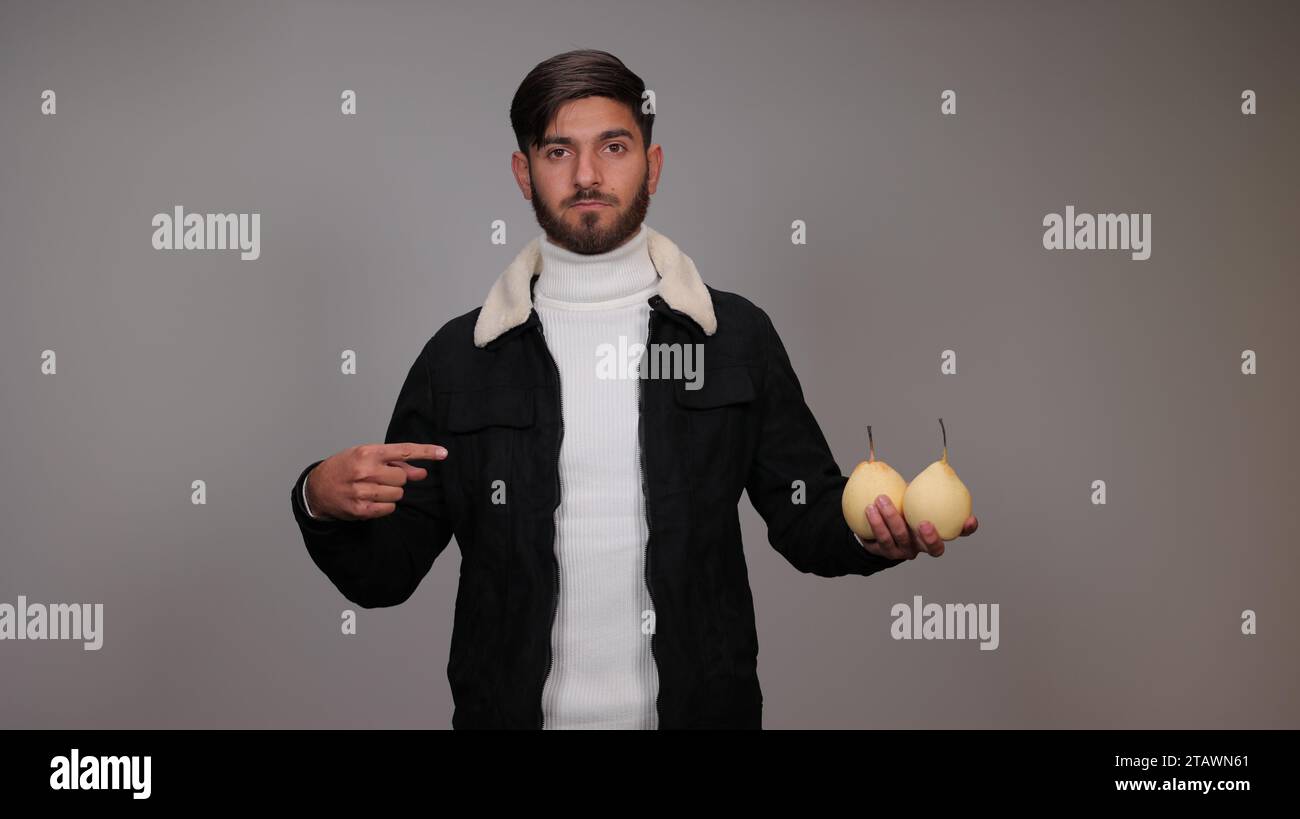 A young man holding pears and encouraging people to eat pears Stock ...