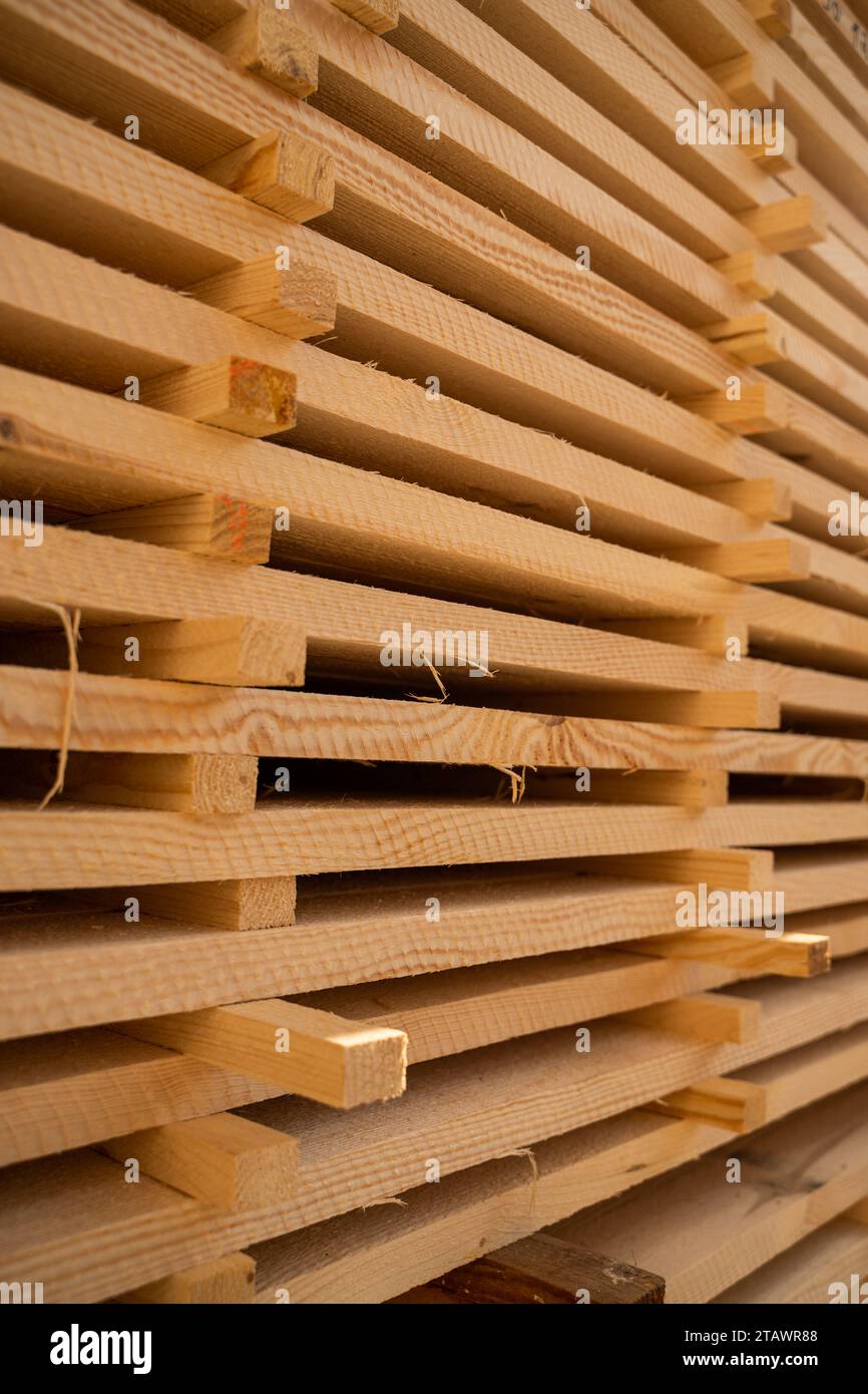 Stacked wooden planks in close-up at a outdoor lumber warehouse. Piles ...