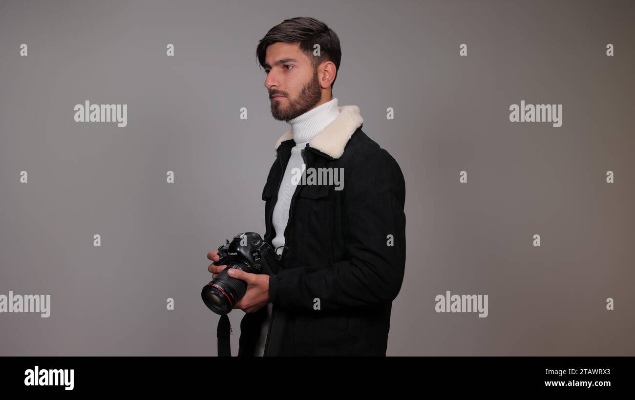 A photographer capturing photos with a camera against a gray background ...