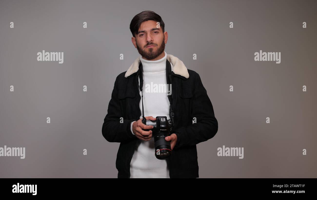 A photographer capturing photos with a camera against a gray background ...