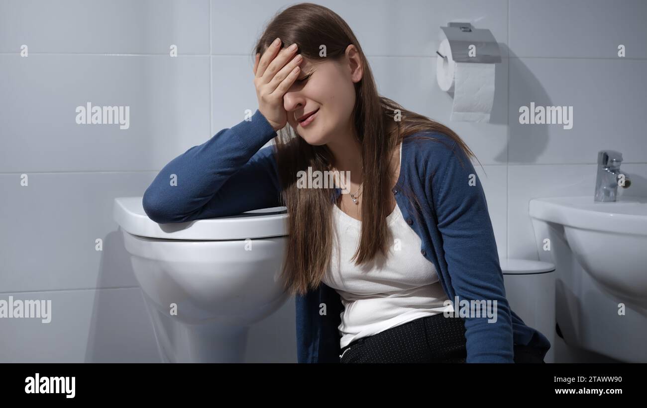 Upset and sad woman crying on floor in toilet at home. Concept of ...