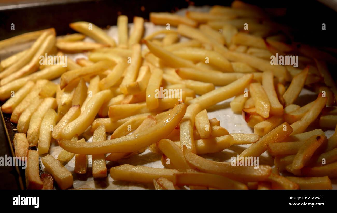 Closeup of pouring oil on frying french fries in oven. Fast food ...