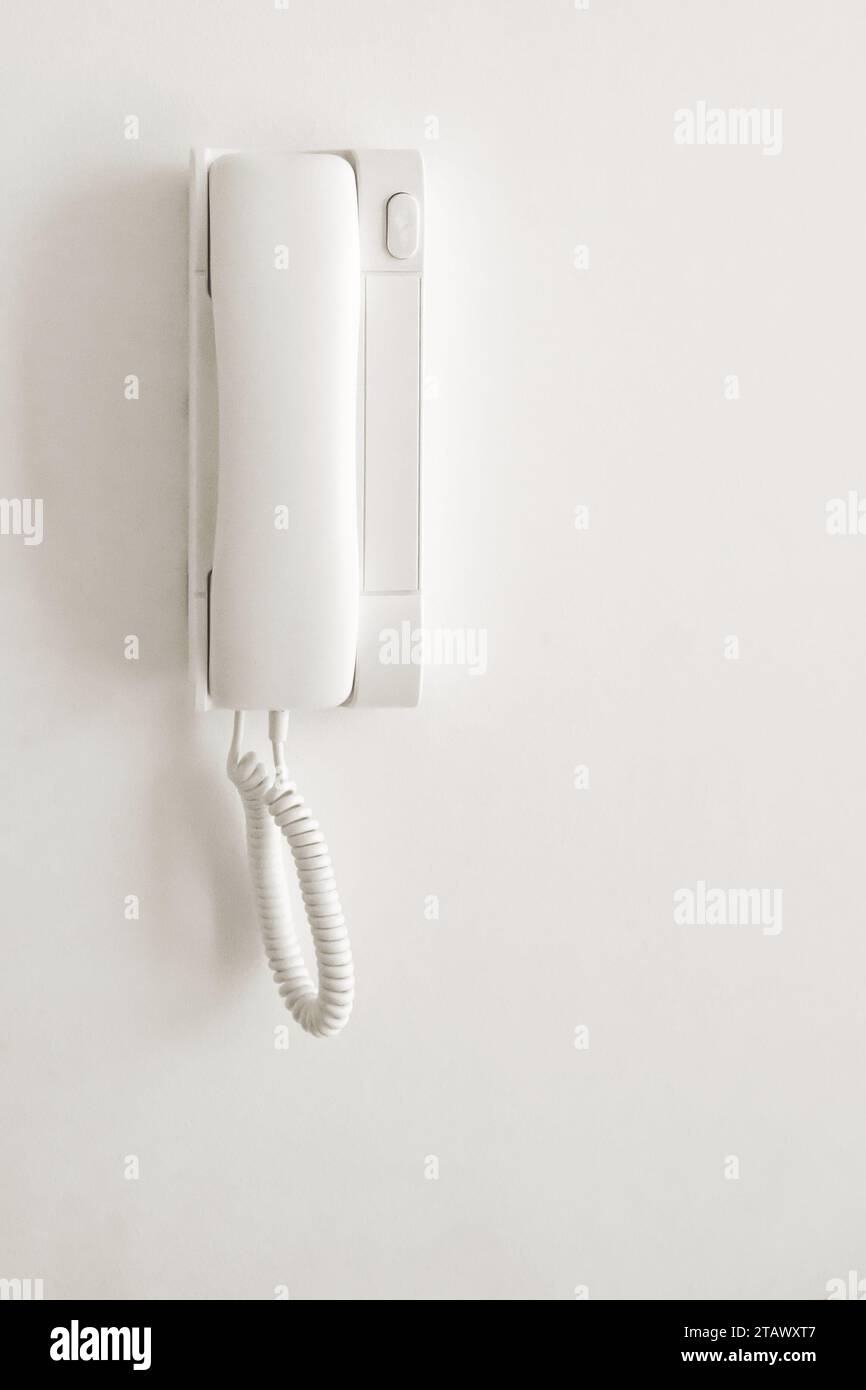 A white landline telephone is mounted on a white wall Stock Photo - Alamy