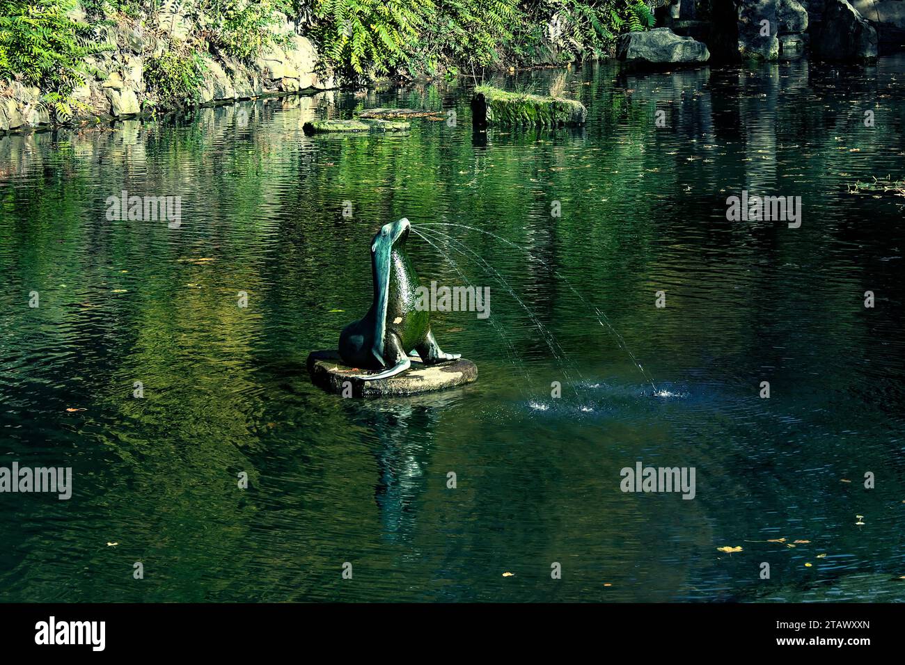 A statue is the focal point of this image, with water spraying from its ...
