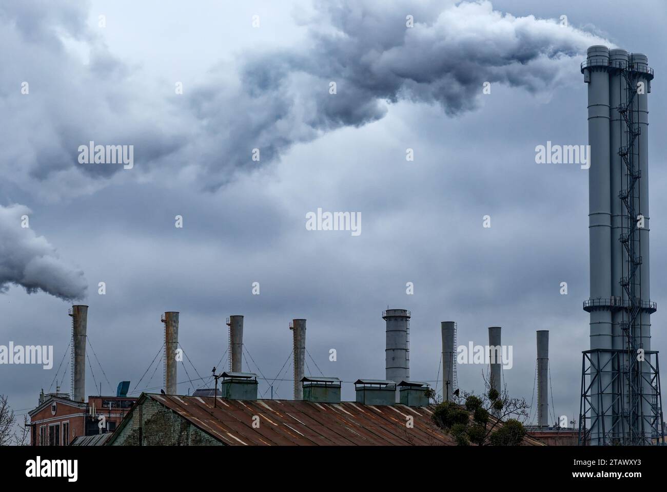 A factory with multiple smokestacks emitting smoke into the sky. The ...
