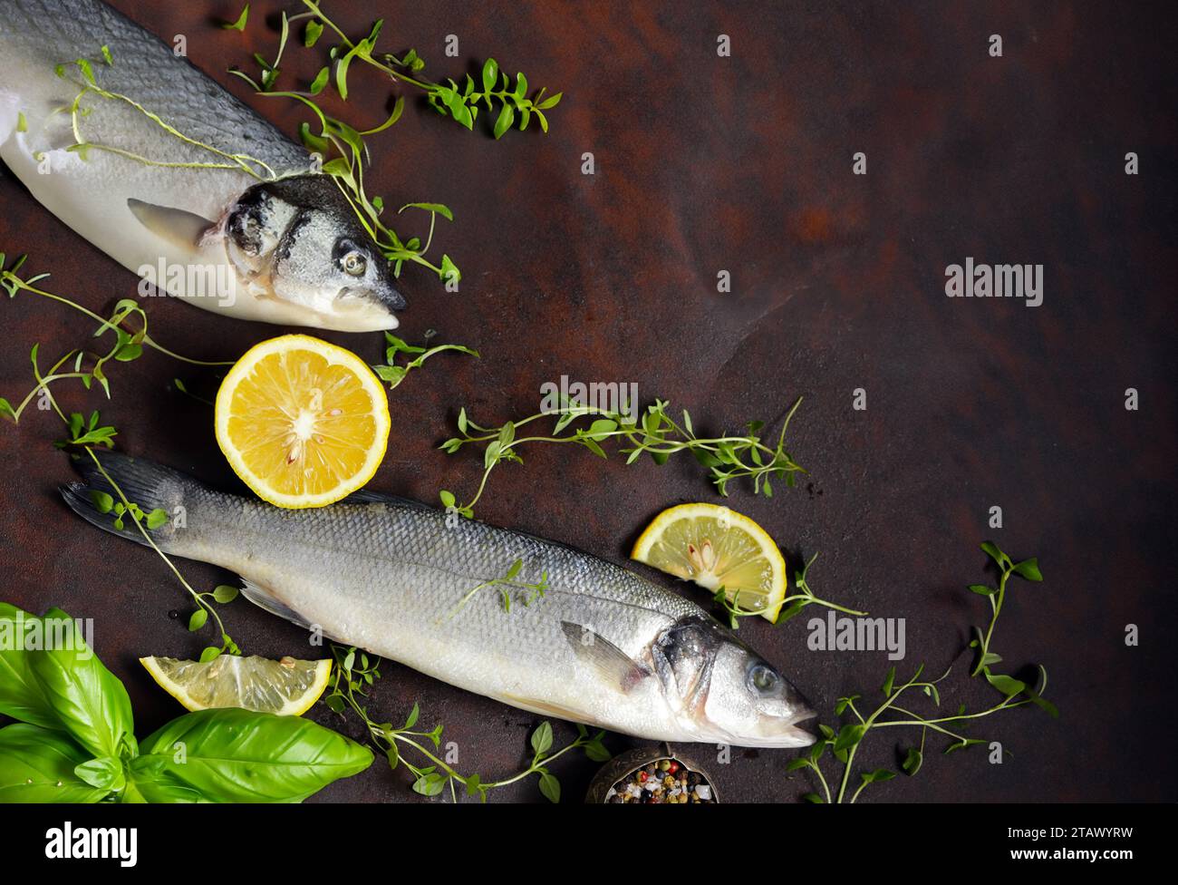 raw fish sea bass and salmon with lemon and herbs Stock Photo - Alamy