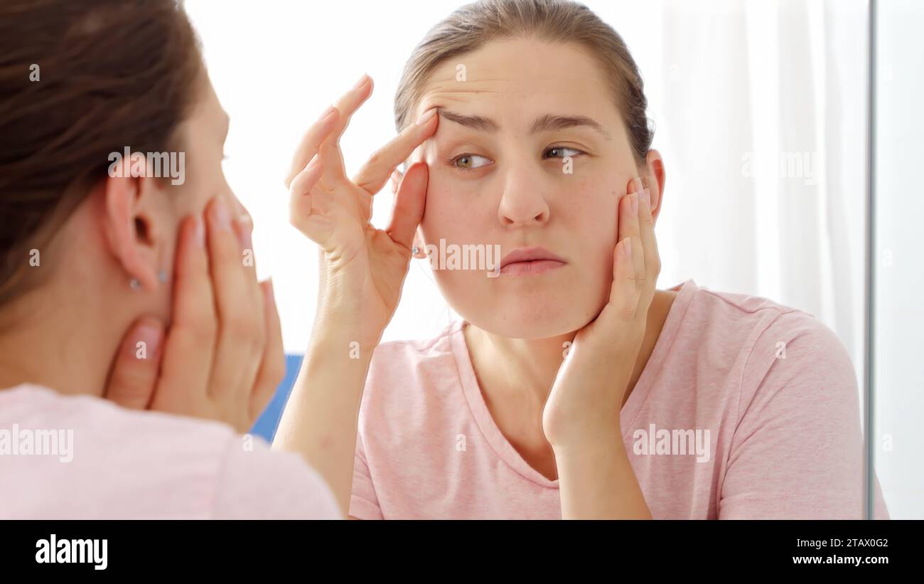 Beautiful 20s Woman Looking In Mirror And Checking Her Face Skin