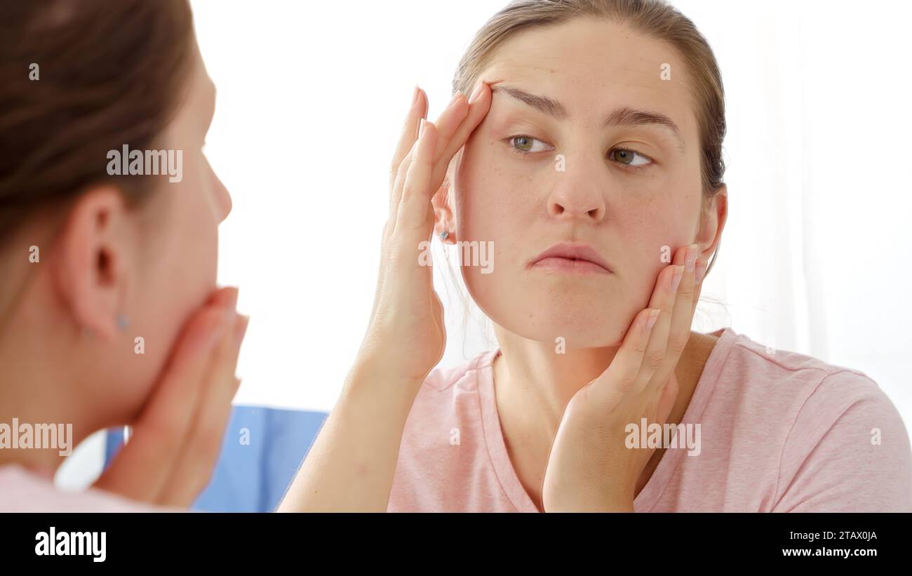 Portrait of young woman pullingher face sking to remove aging wrinkles ...