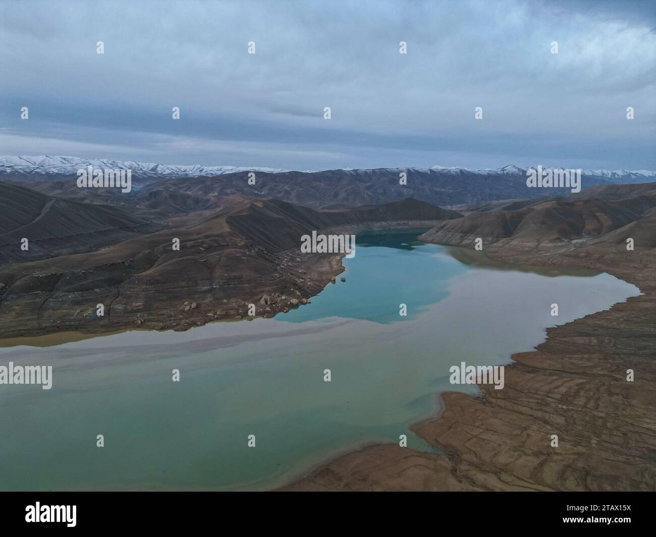 A river flowing through a green village and mountains in Afghanistan ...