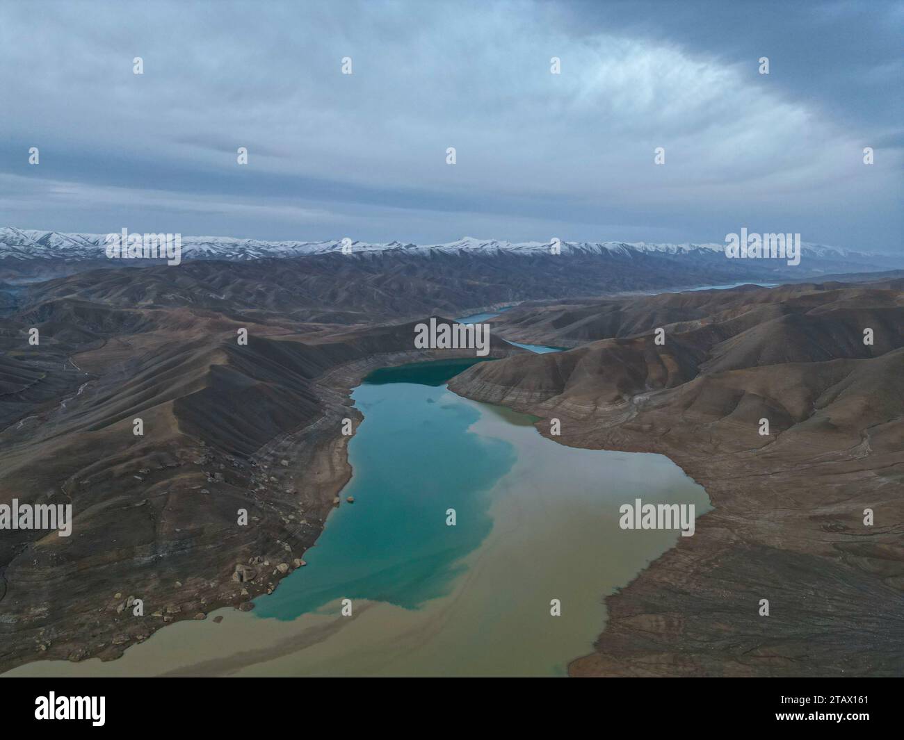 A river flowing through a green village and mountains in Afghanistan ...