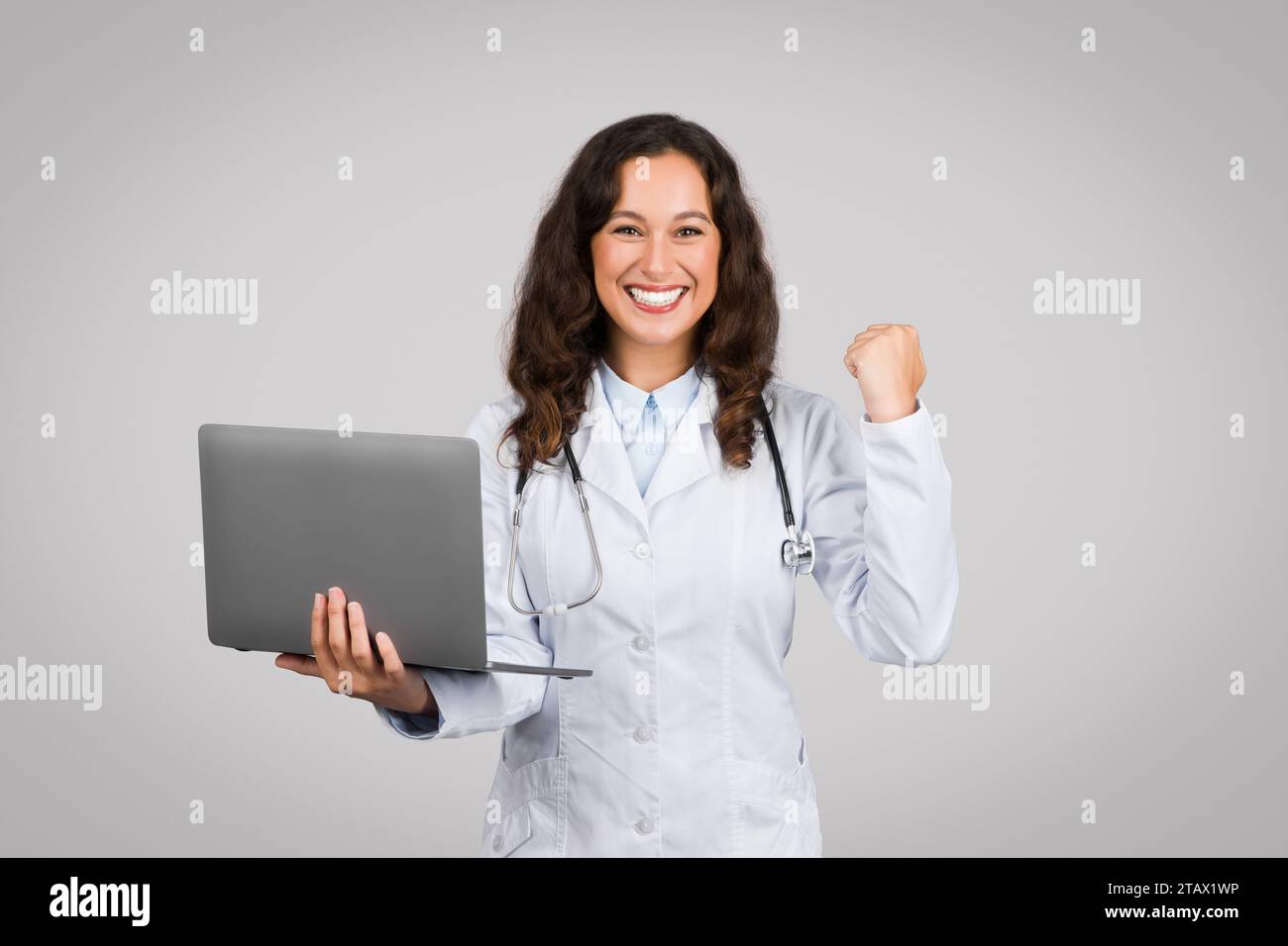Victorious woman doctor with laptop celebrating success Stock Photo - Alamy
