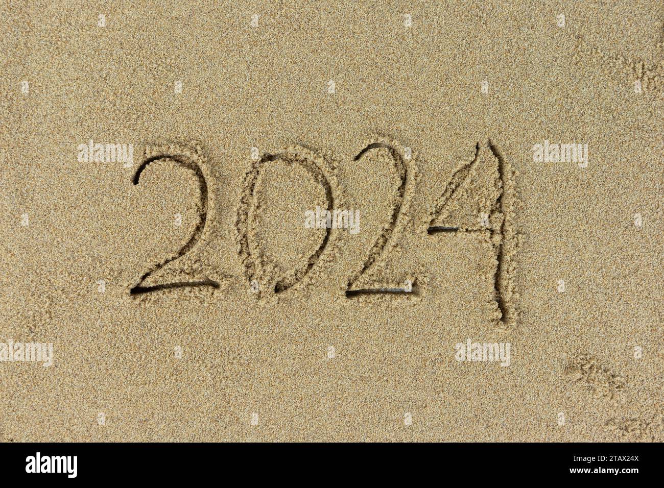 Handwritten 2024 on clean beach sand. Happy New Year Stock Photo - Alamy