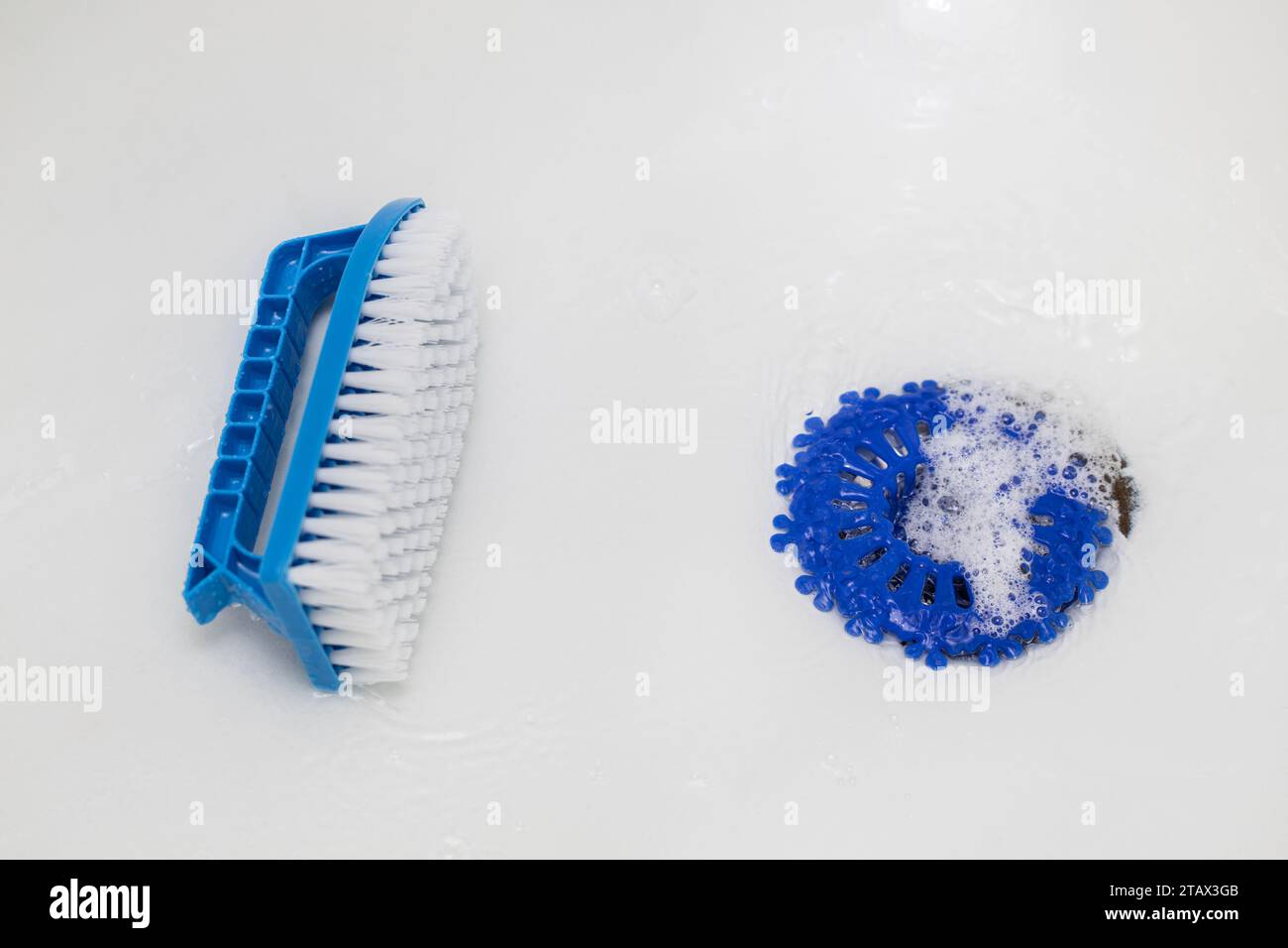 cleaning a white bathtub with a brush. foam in the bathtub drain hole. High quality photo Stock ...