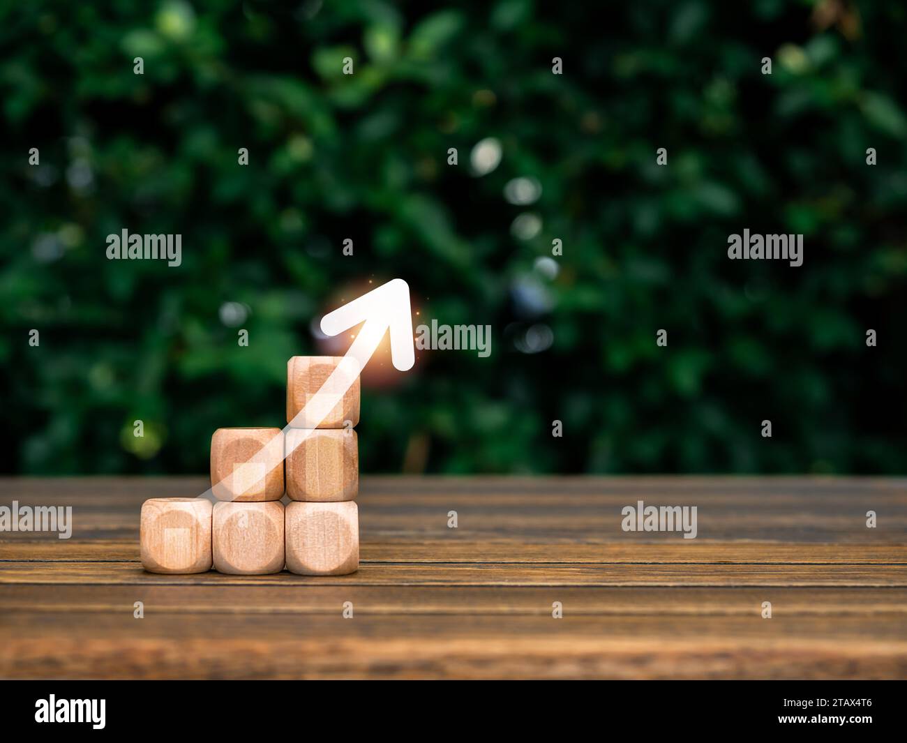 Rising up glowing arrow on empty wooden cube blocks as a business graph ...