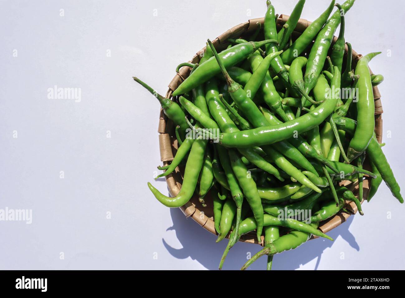 Freshn green chillies in a basket on white background Stock Photo - Alamy