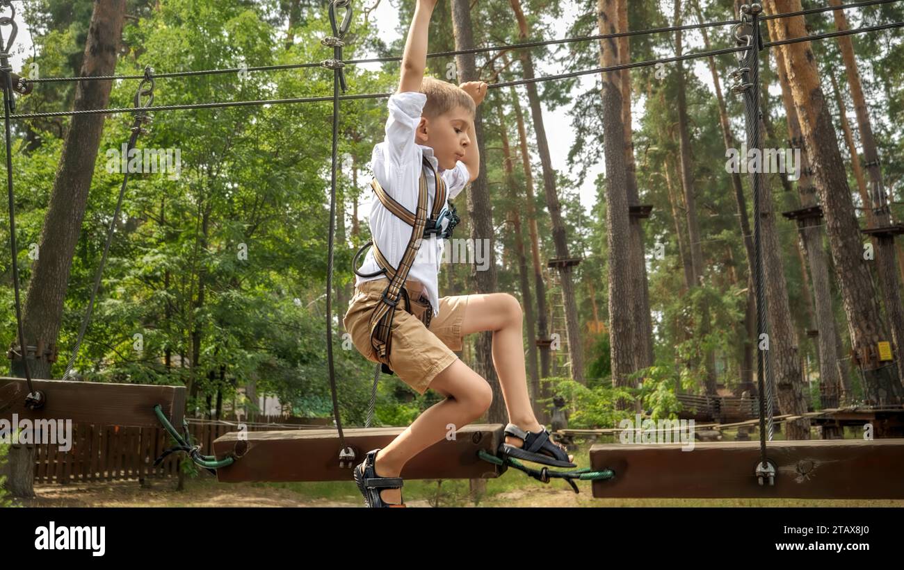 Little boy walking over rope bridge and falling down. Kids sports ...