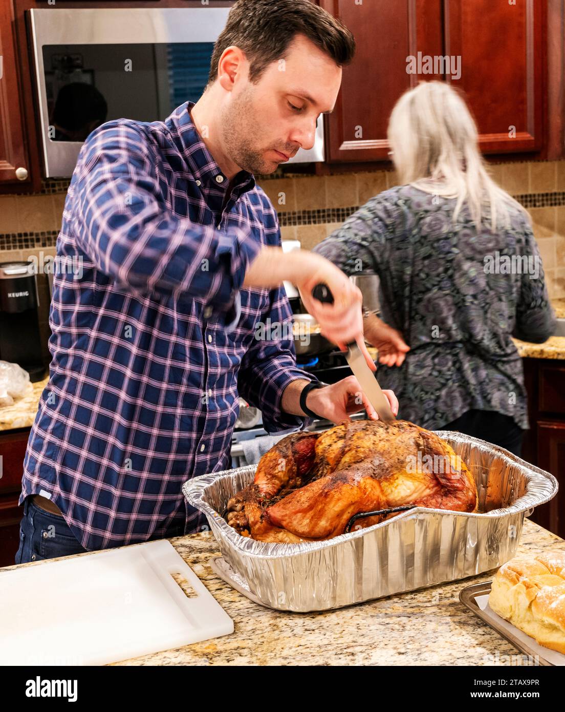 Young male preparing turkey for Thanksgiving family gathering Stock ...