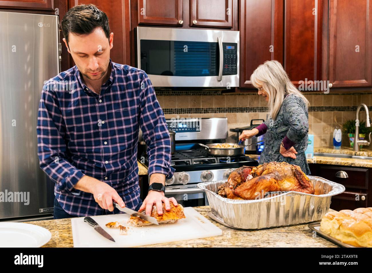 Young male preparing turkey for Thanksgiving family gathering Stock ...