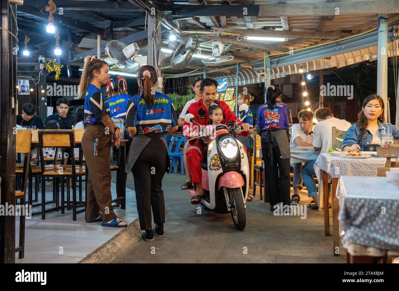 A traditional street restaurant with a narrow passage for scooters in ...