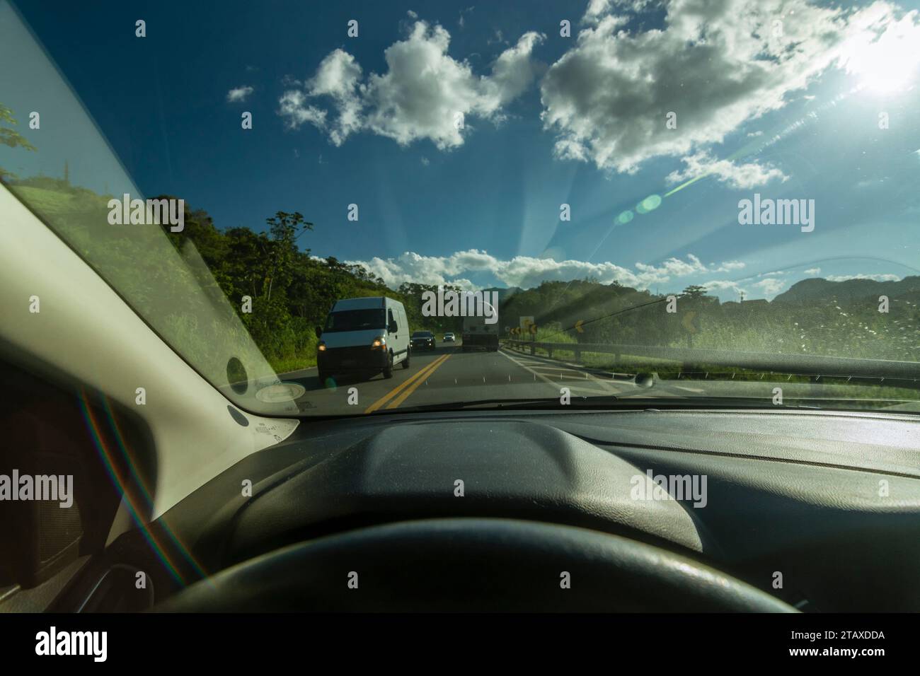 Driving the car on the busy road on a sunny day. Blue sky with white ...