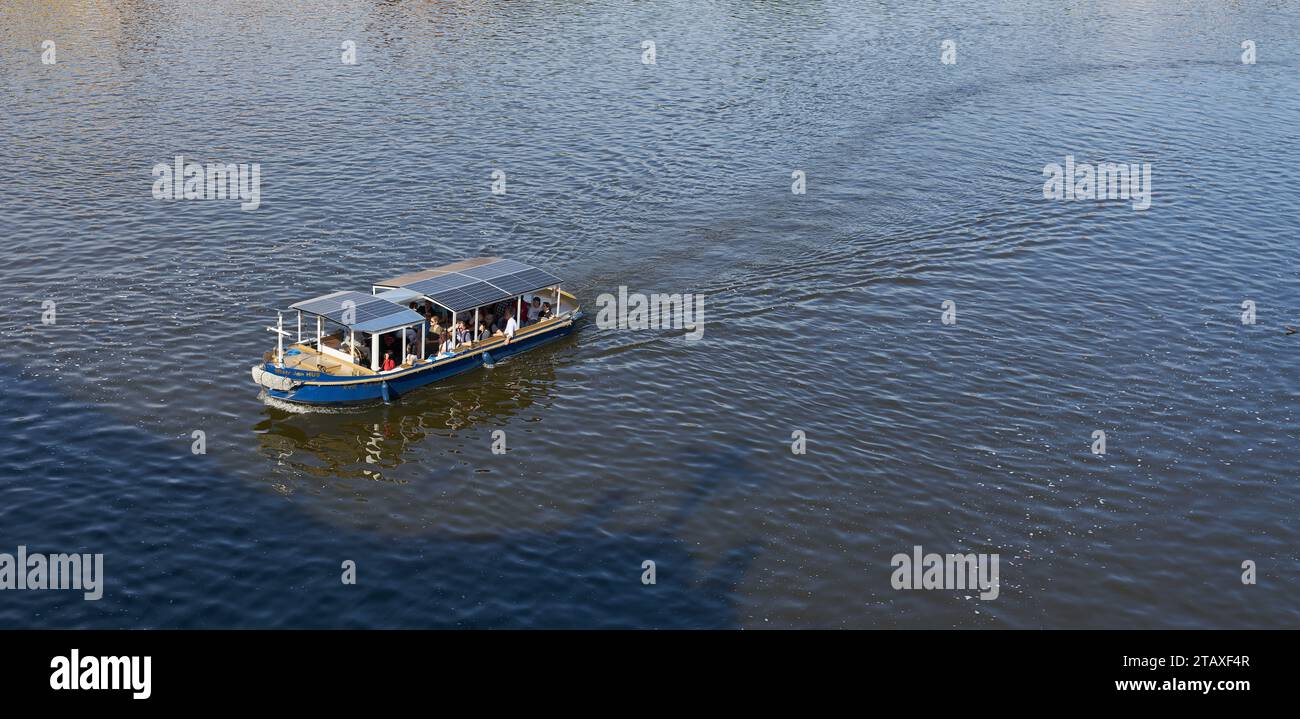 Small solar-powered excursion boat on the Vltava River in Prague. The ...
