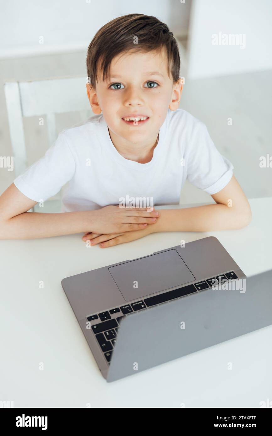 A boy sits in a lesson at a computer a student school learning online ...