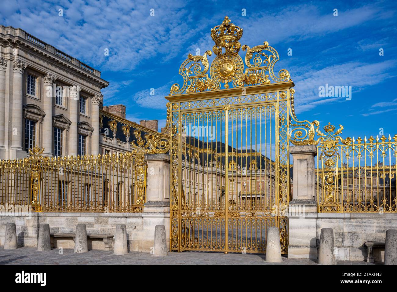 Golden entry gates of Chateau De Versailles with setting sunlight ...