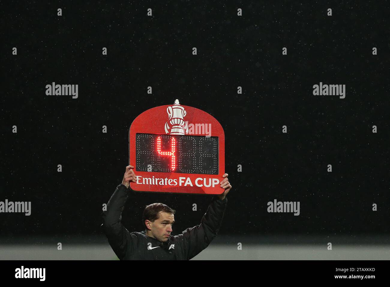 The fourth official holds up the extra time board showing four ...