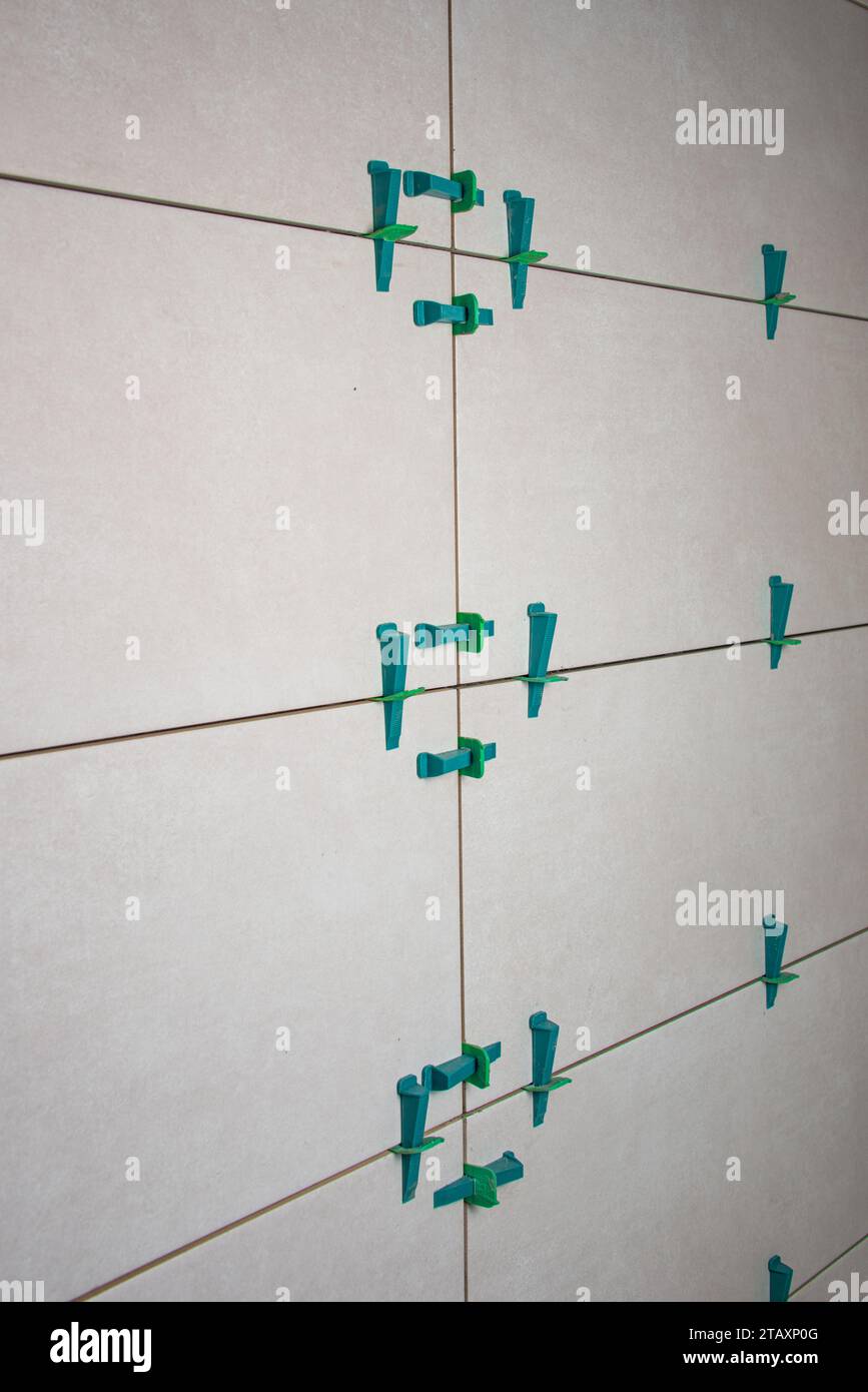 Tile leveling system with plastic clips and wedges, shot while the tile ...