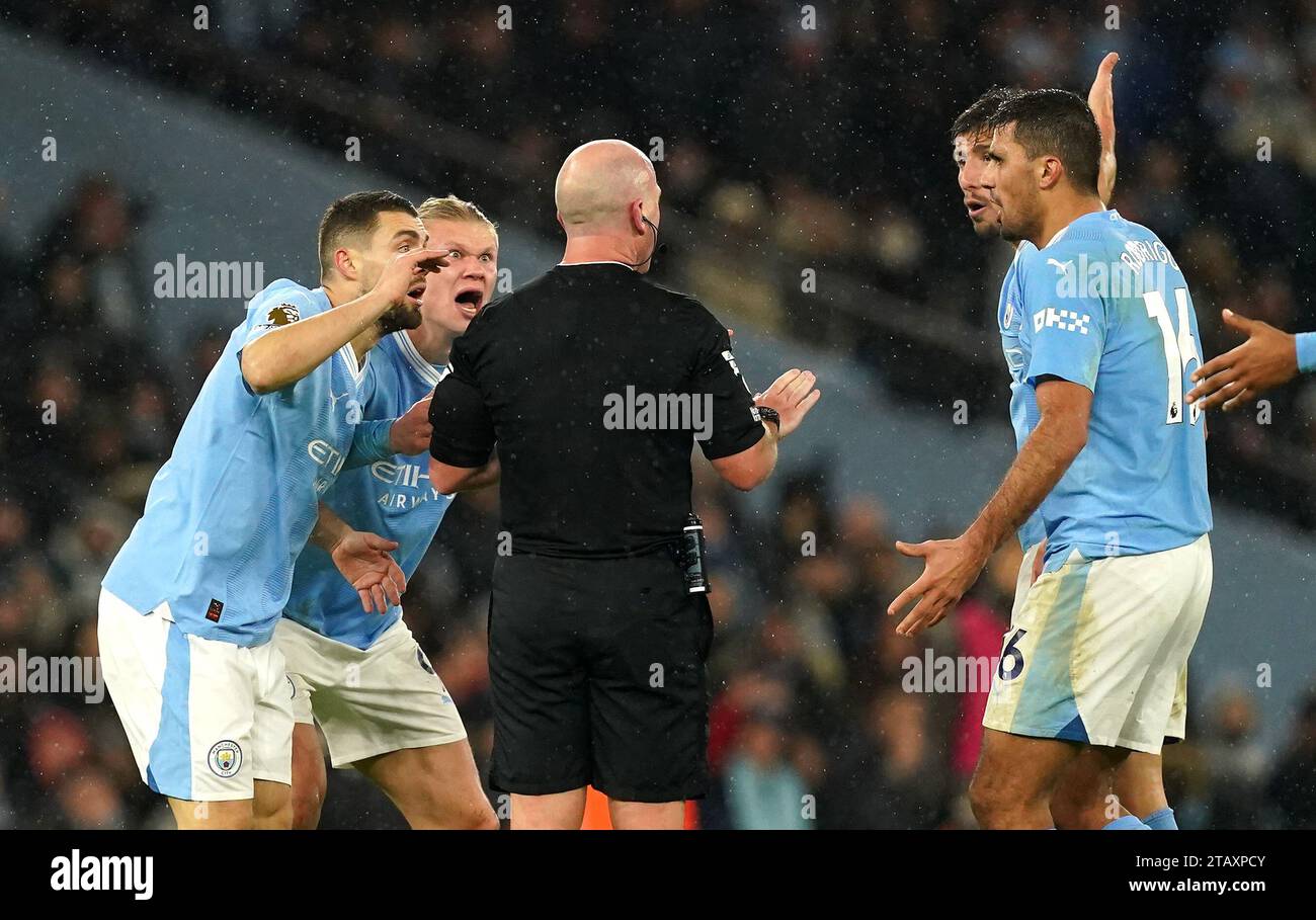 Manchester City players react after referee Simon Hooper (centre) stops ...