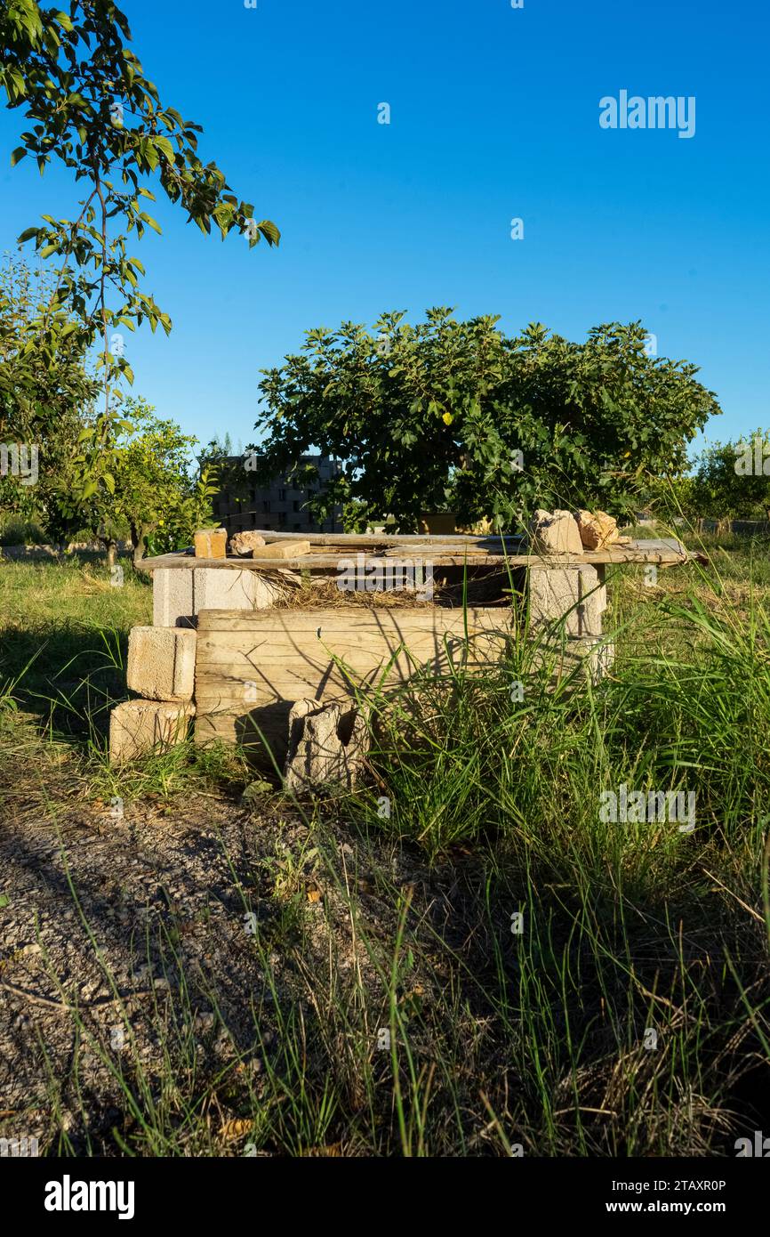 Artisanal composter built rustically, is full of branches and ...