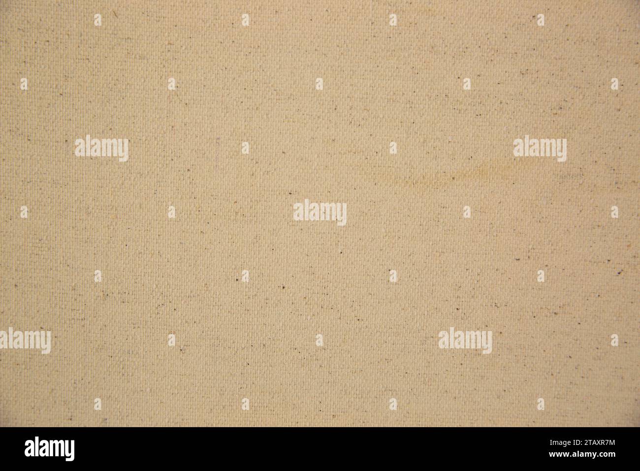 A beige-colored fabric background with a sewn pattern of concentric ...