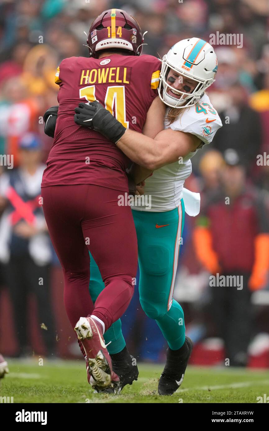 Washington Commanders quarterback Sam Howell, left, is hit by Miami ...