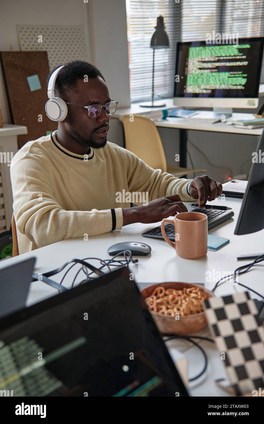 Back end developer listening to music in headphones when coding on ...