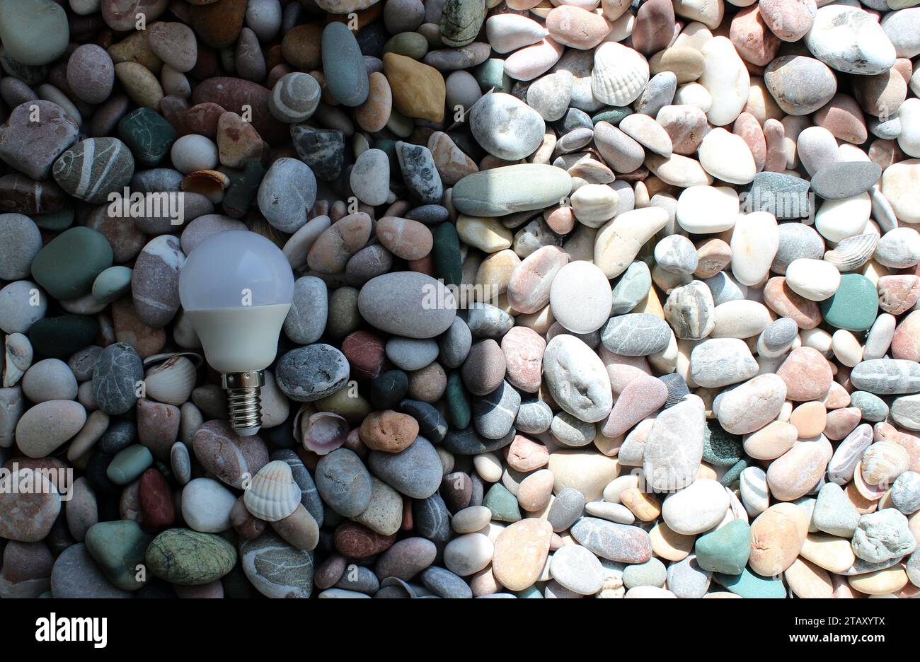 Sunlight separates sea pebbles texture with energy saving round lamp ...