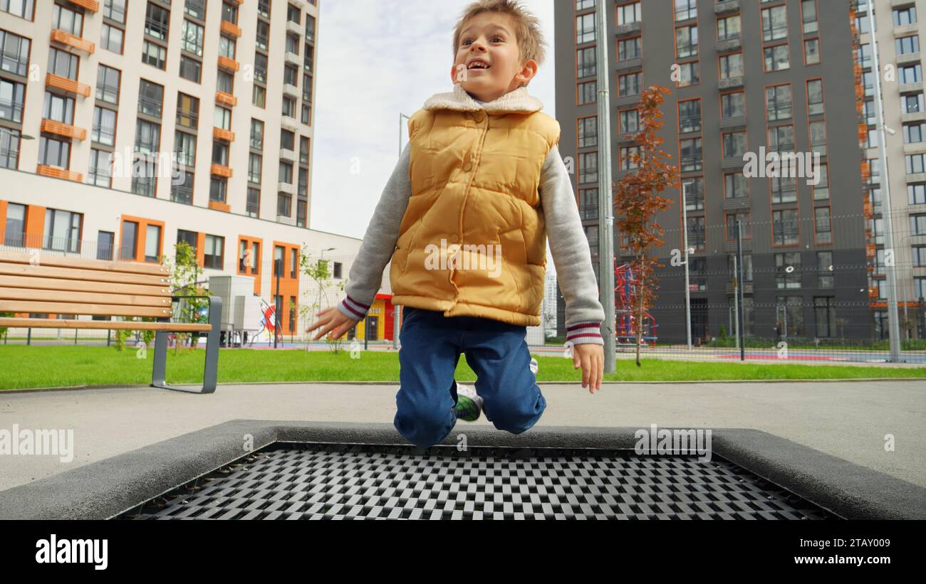 Slow motion of happy child enjoying jumping on trampoline at playground ...