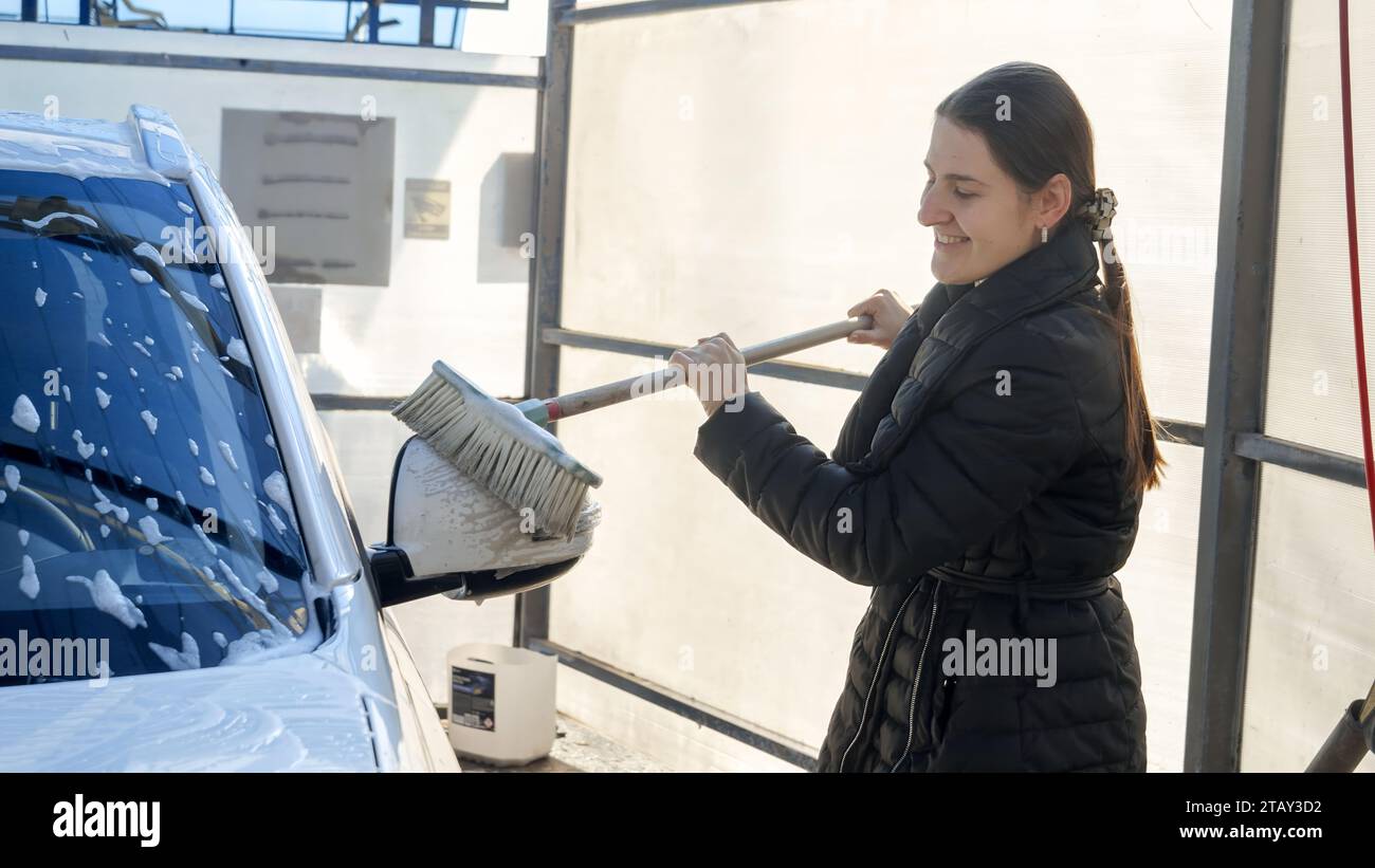 Beautiful woman washing her car at self service carwash. Automobile ...