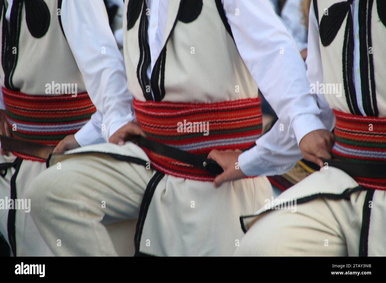 A group of traditional Balkan folk dancers performing in an outdoor ...