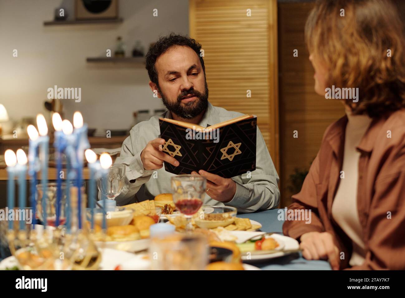 Serious mature Jewish man with open Torah reading Scripture texts or ...