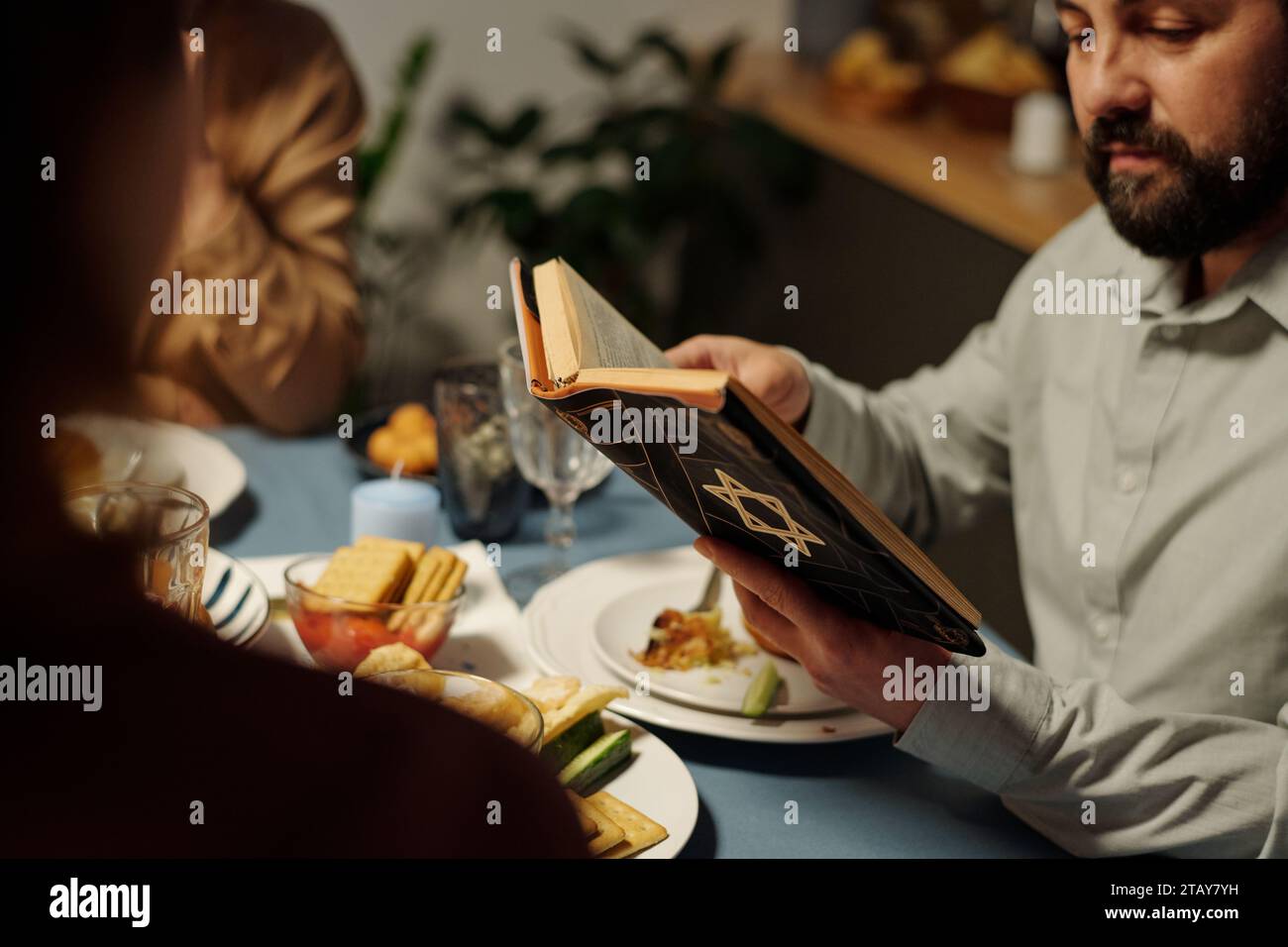 Close-up of mature Jewish man holding open Old Testament over served ...