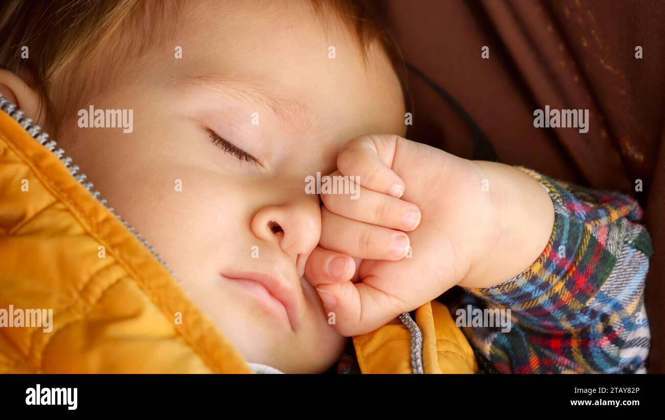 Closeup of sleeping baby's face lying in stroller at park. Child ...