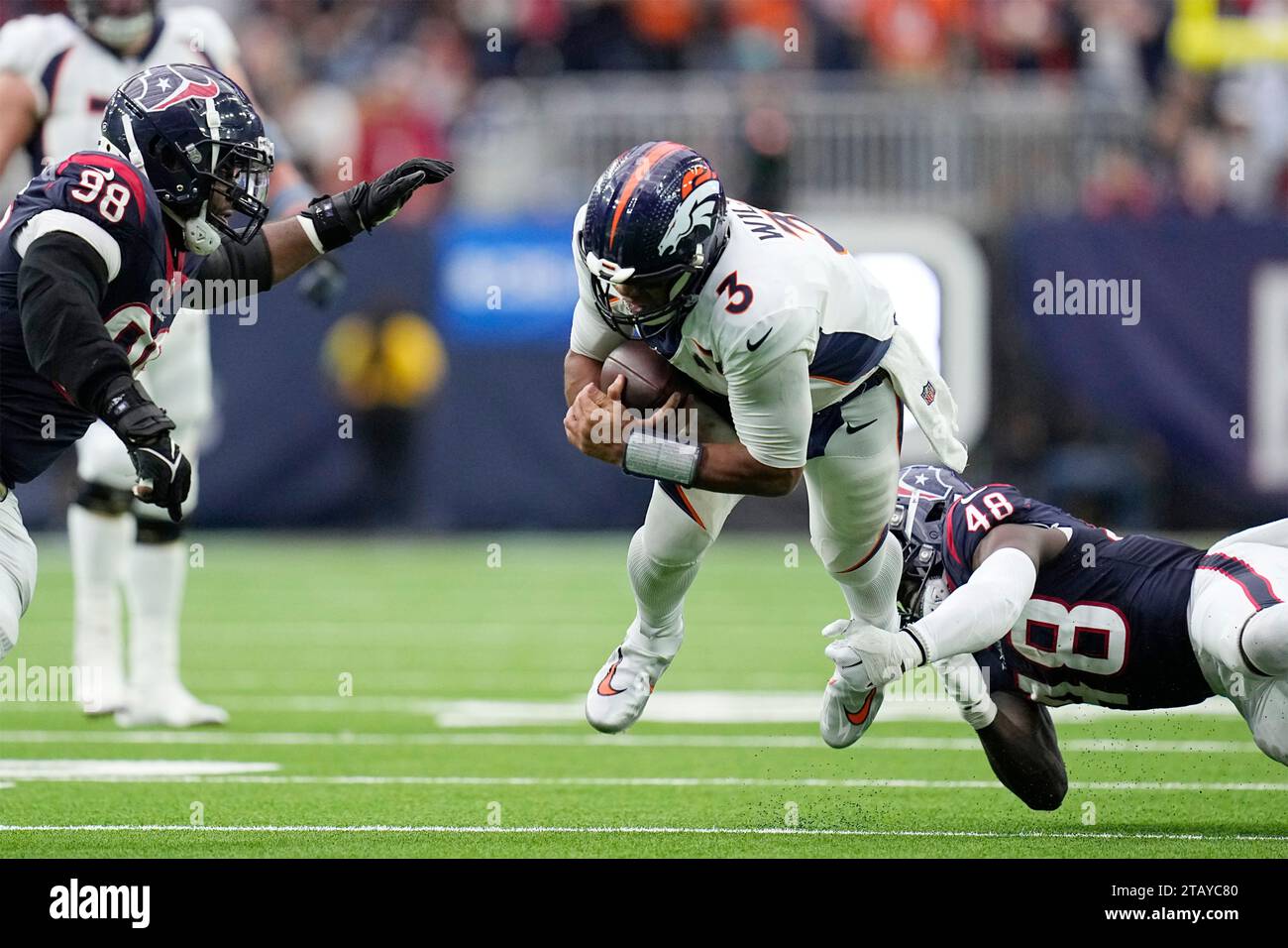 Denver Broncos quarterback Russell Wilson (3) is brought down by ...