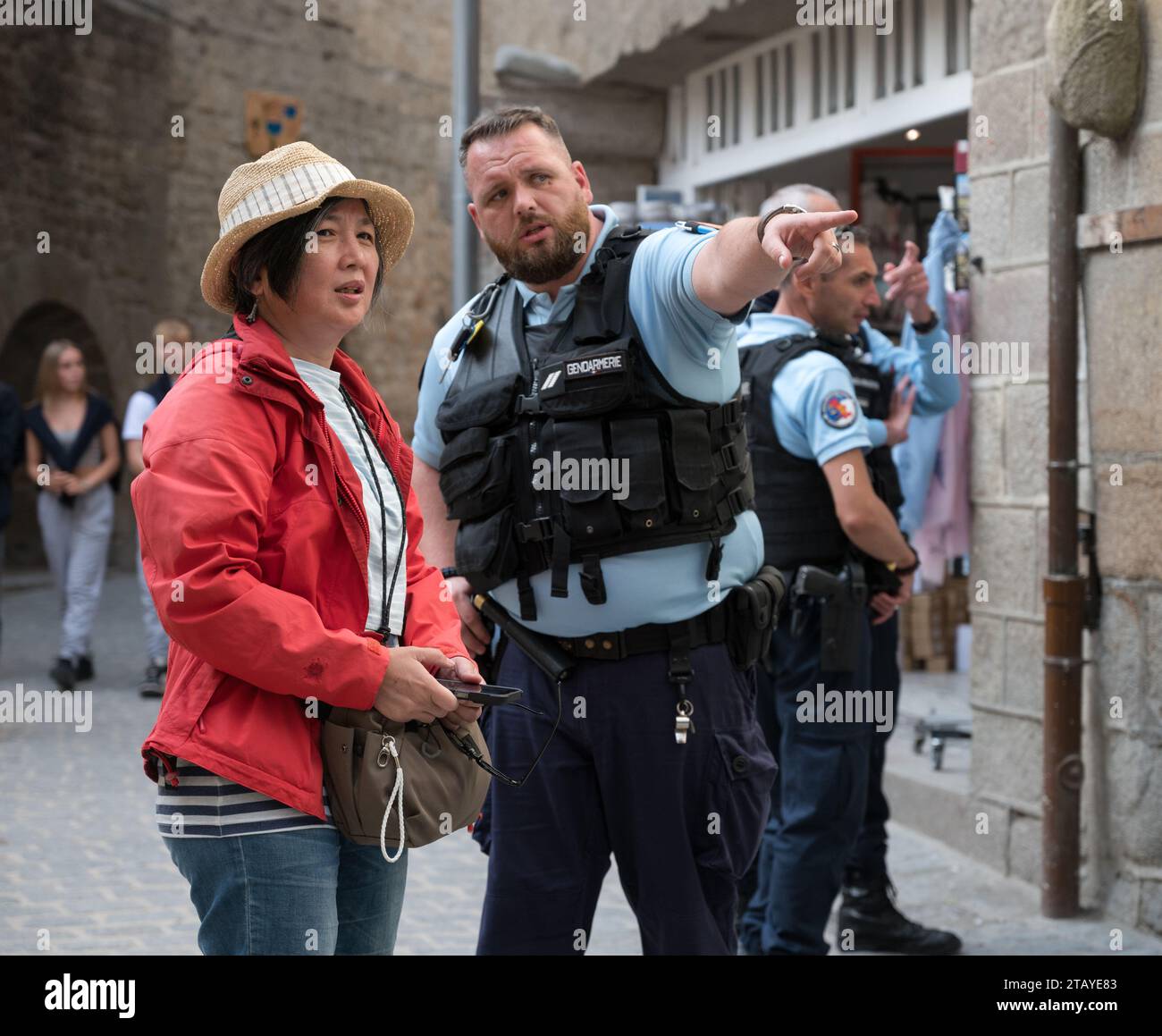 A French police officer giving an address to an Asian tourist on Mont ...
