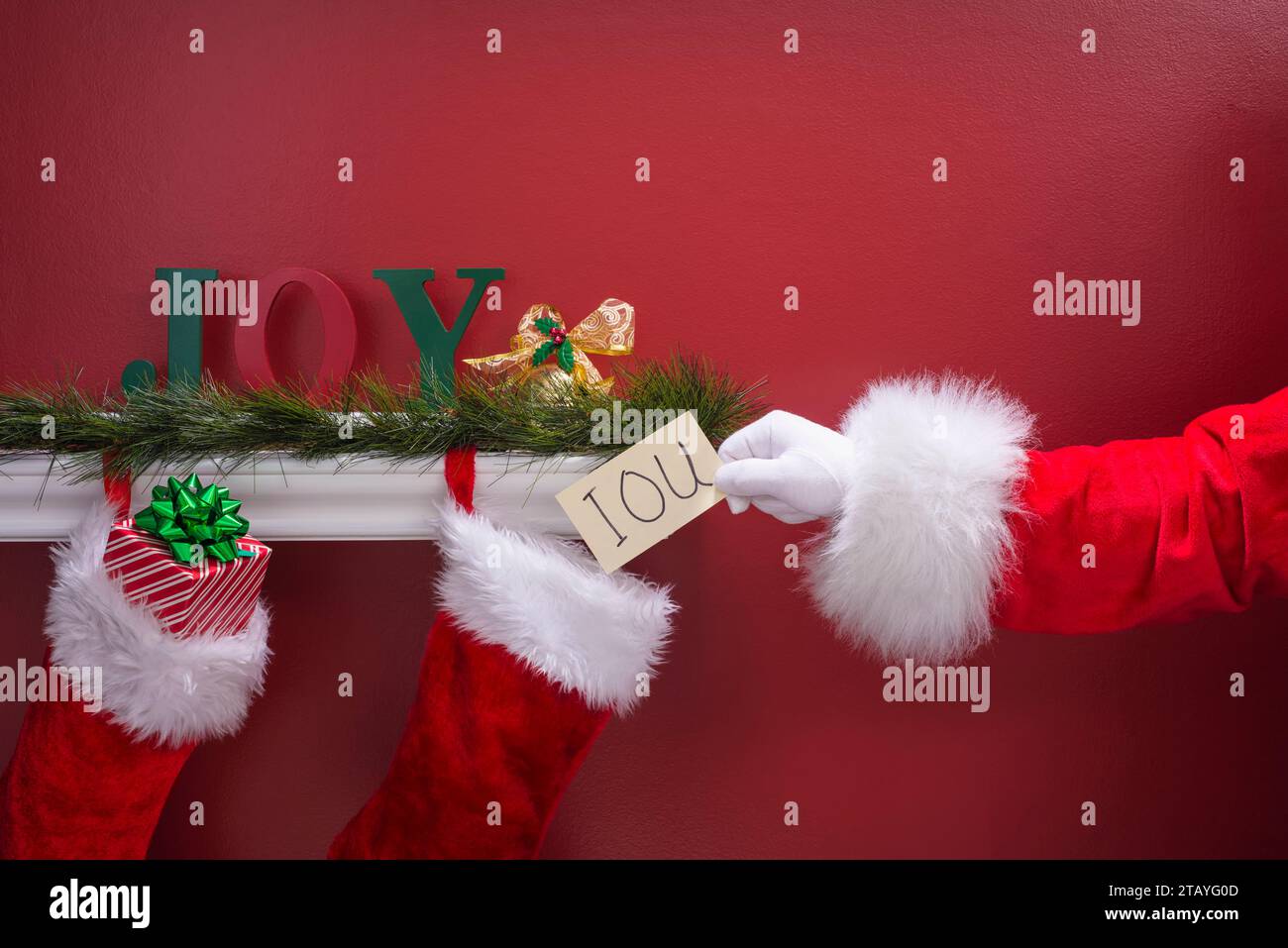 Santa Claus placing an IOU note into Christmas stocking hanging from ...
