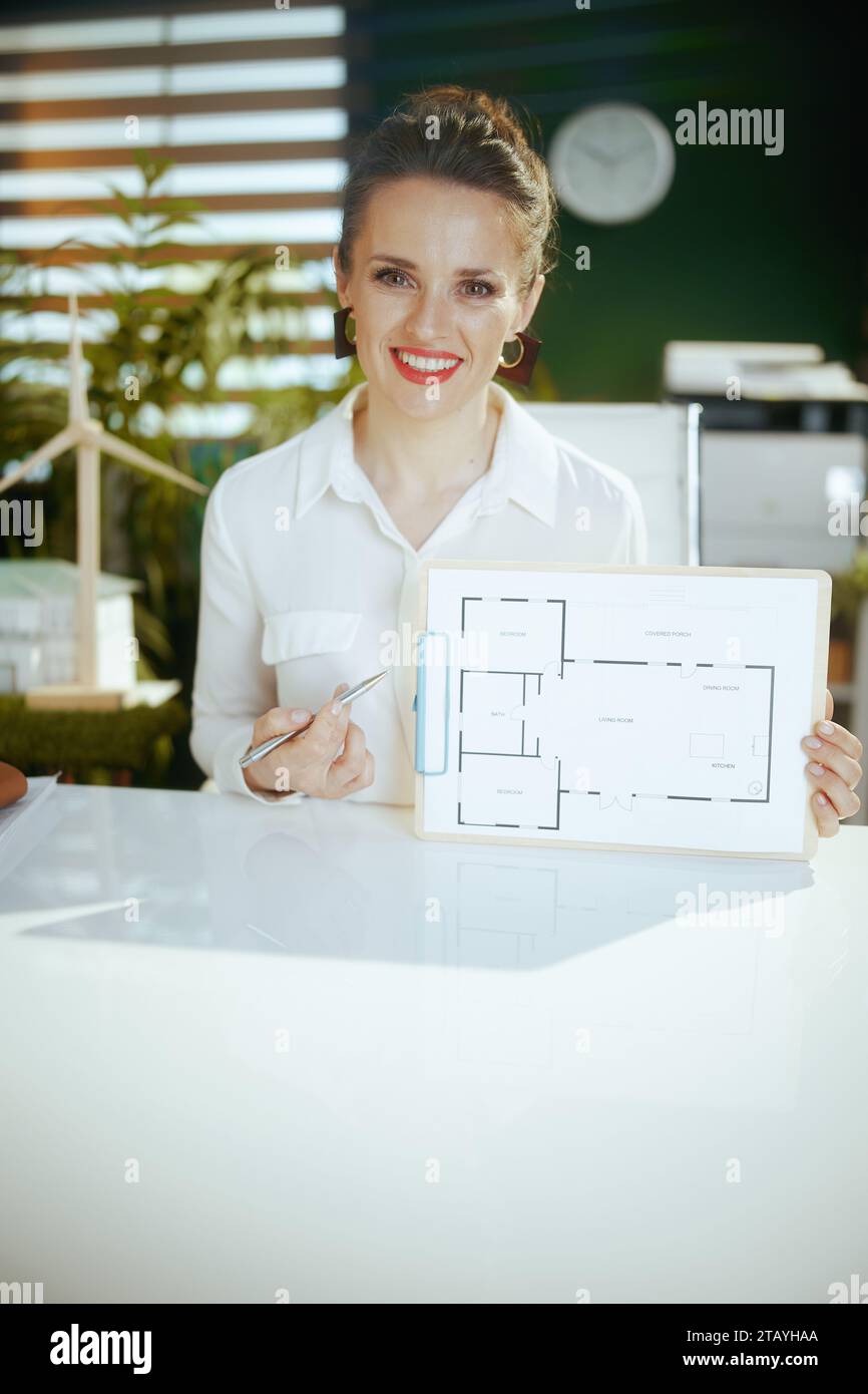 Time to move on. happy elegant female real estate agent in modern green ...