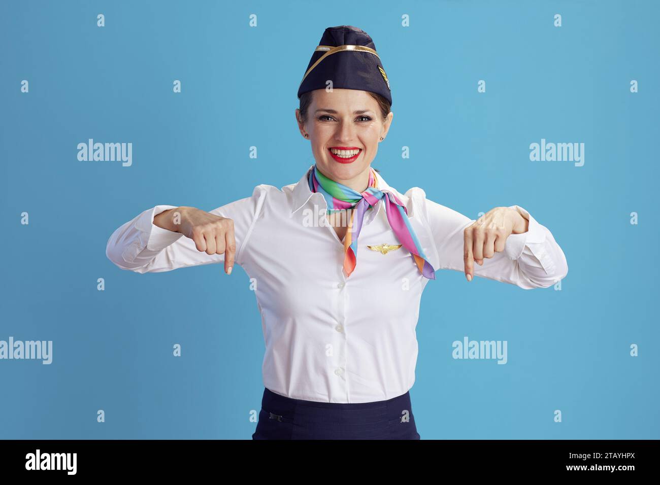 smiling modern female air hostess against blue background in uniform ...
